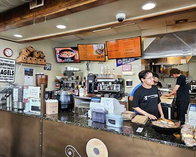 Behind that counter, the magic happens: fresh coffee brewing, bagels toasting, and orders flying with impressive precision.
