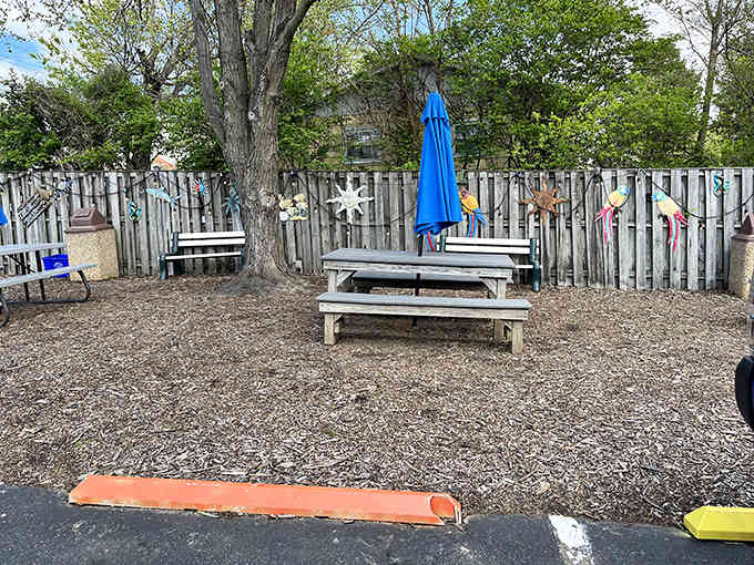 Picnic tables under shade trees create the perfect spot for savoring burgers while pretending you're oceanside.