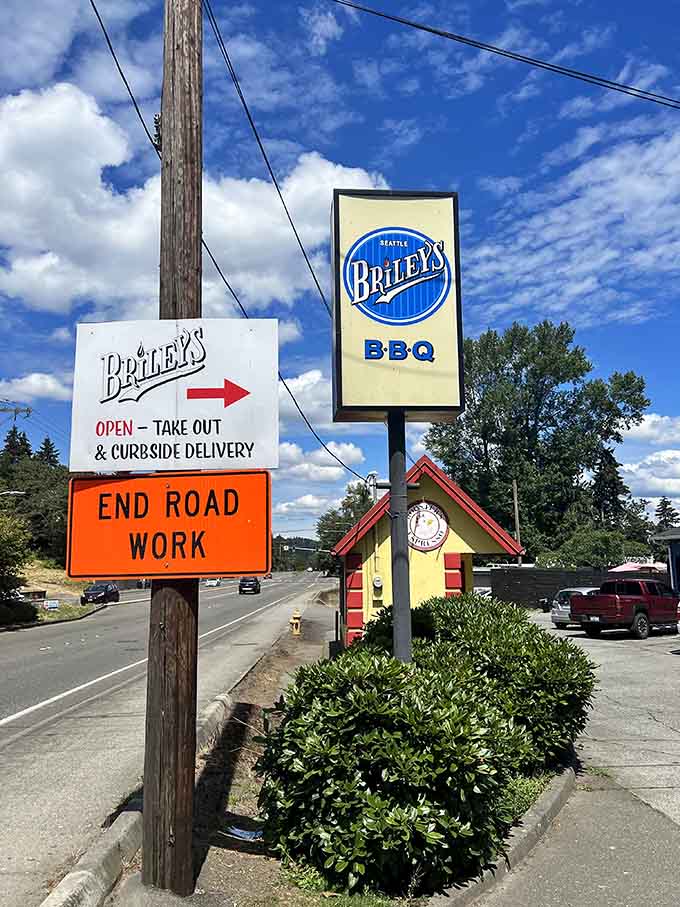 The roadside sign beckons hungry travelers with promises of takeout, curbside delivery, and barbecue satisfaction guaranteed.