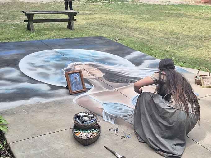 A street artist creates stunning chalk portraits, her medieval dress pooling around her as masterpieces emerge from pavement.
