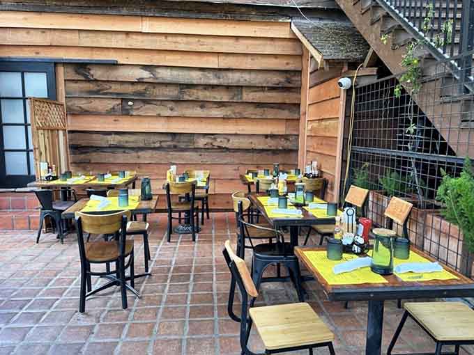Brick patio seating with yellow placemats waiting for guests, because even the tables here get that California sunshine vibe.
