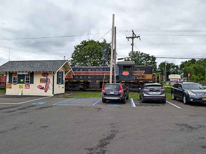 The charming station and waiting locomotives create a scene that belongs on a nostalgic postcard collection.