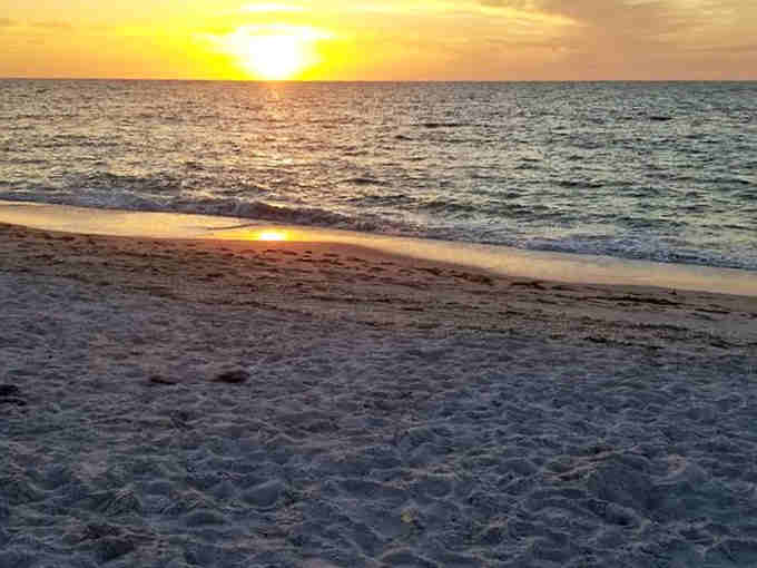 Golden hour transforms the Gulf into liquid fire, proving nature's the ultimate show-off every single evening.