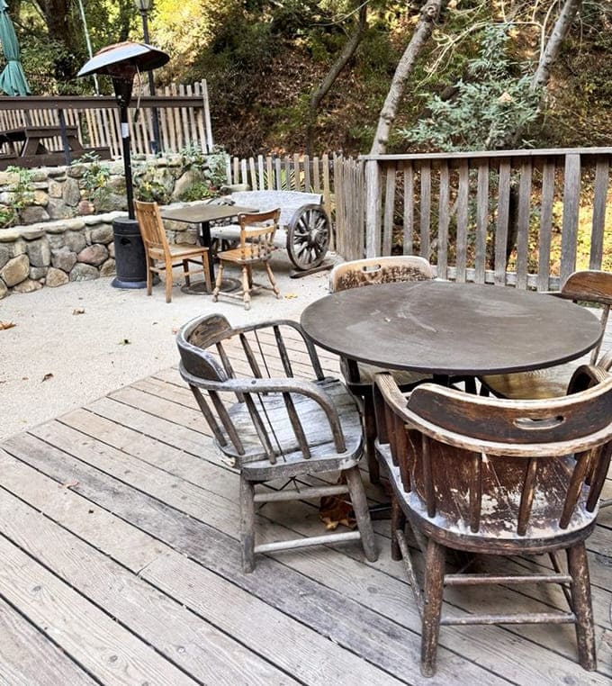 Outdoor seating nestled among the trees, where nature provides the soundtrack and rustic furniture completes the time-travel experience perfectly.