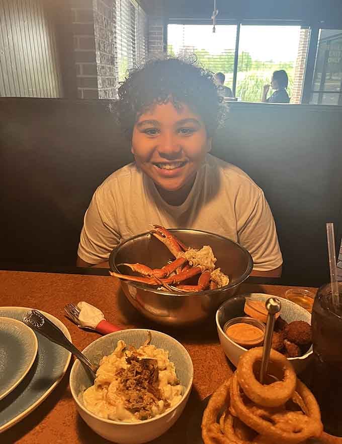 Pure joy captured in one photo: a happy diner, a bucket of crab, and endless possibilities ahead.