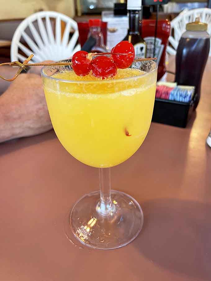 Even the drinks arrive looking cheerful, garnished with maraschino cherries like tiny edible party hats for your beverage.