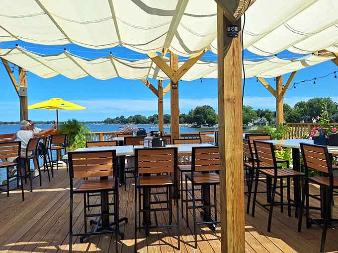 Deck seating with sailcloth canopy overhead, where every meal comes with a side of Tred Avon River.