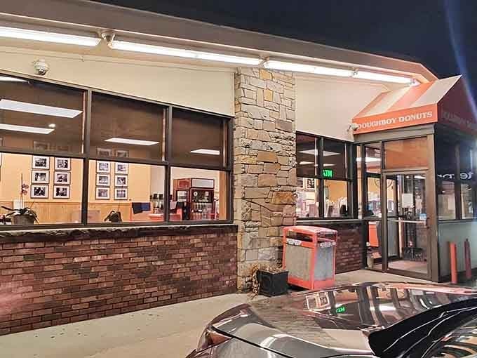 The storefront at night glowing like a lighthouse for hungry travelers seeking refuge in fried dough.