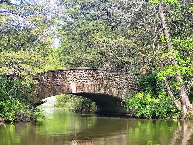 The stone bridge over water adds a touch of storybook charm to your afternoon stroll.