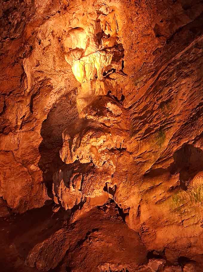 Golden light bathes layered stalactites in warm amber tones, showcasing the cave's most photogenic geological masterpiece perfectly.