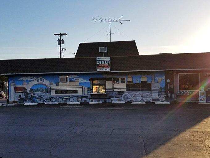 That train mural stretches across the building like a love letter to America's railroad heritage, painted in sunset-kissed glory.