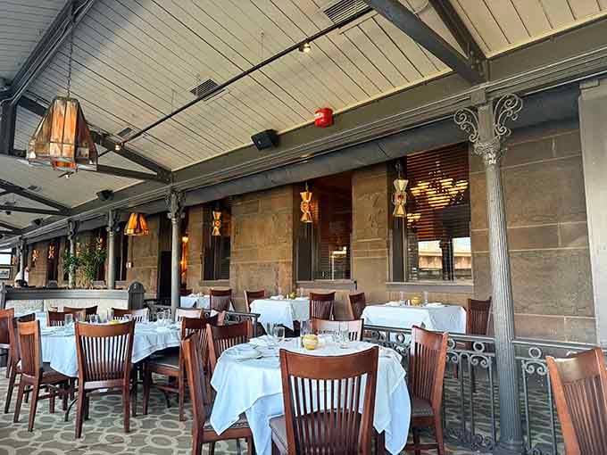 The covered patio offers riverside dining with architectural charm that beats any chain restaurant's ambiance.