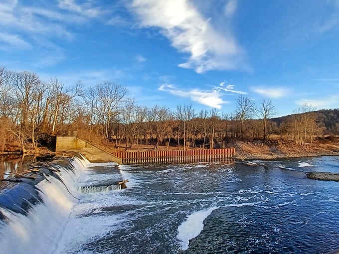 The nearby dam adds another layer of scenic beauty to an already picturesque spot along the river.