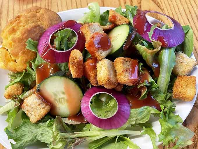 Fresh salad with vibrant vegetables and croutons: proof that healthy options exist even in pancake paradise.