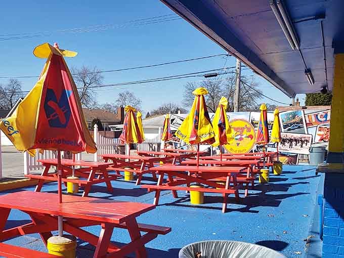 Outdoor seating painted brighter than a summer sunset invites you to enjoy your meal under cheerful umbrellas today.