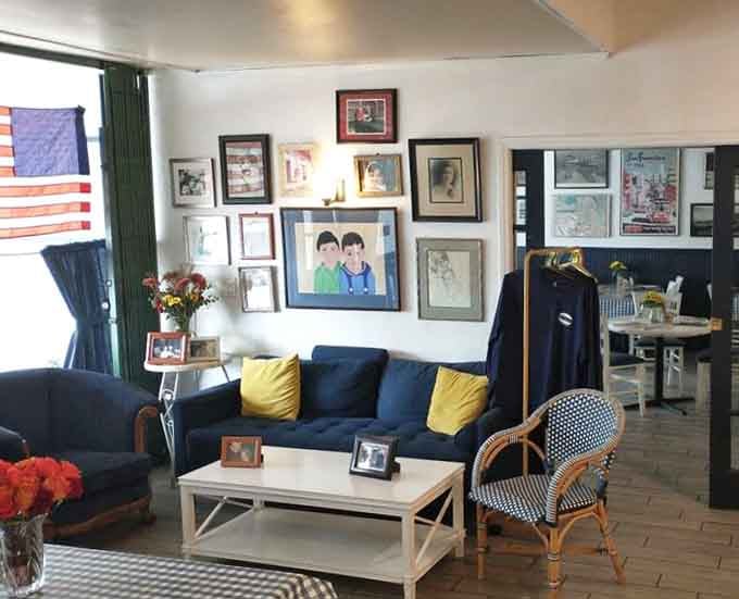 The cozy waiting area with its gallery wall suggests you're about to experience something worth the inevitable wait.