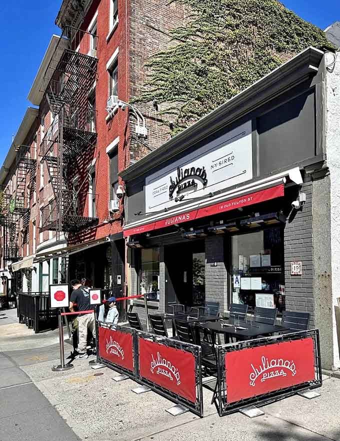Sunny sidewalk seating where you can people-watch while devouring slices that justify any wait time.