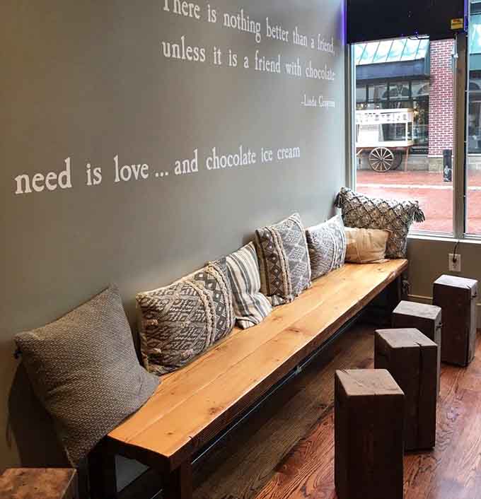 Cozy bench seating with pillows and chocolate wisdom on the walls makes lingering here absolutely mandatory.