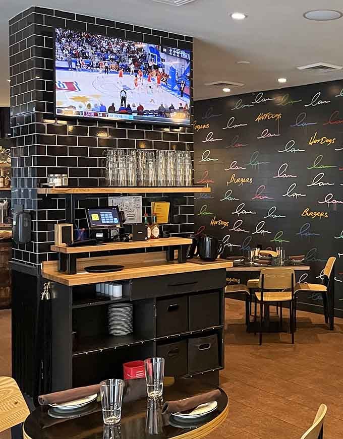 The serving station stands ready with TVs for sports, because watching athletes while eating massive burgers feels appropriately ironic.