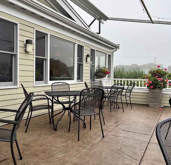 Outdoor patio seating with planters full of geraniums, because even casual seafood shacks deserve a little floral beauty.