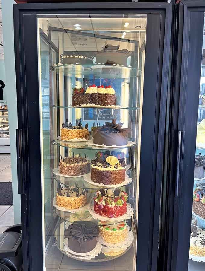 Custom cakes stacked in the display prove special occasions deserve more than grocery store sheet cakes ever deliver.