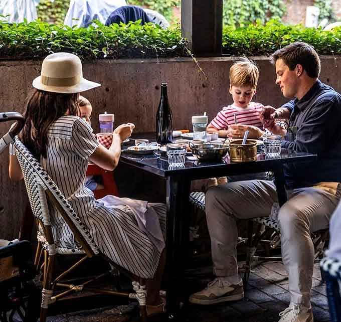 Families gather over wine and conversation, proving French dining culture welcomes everyone to the table.