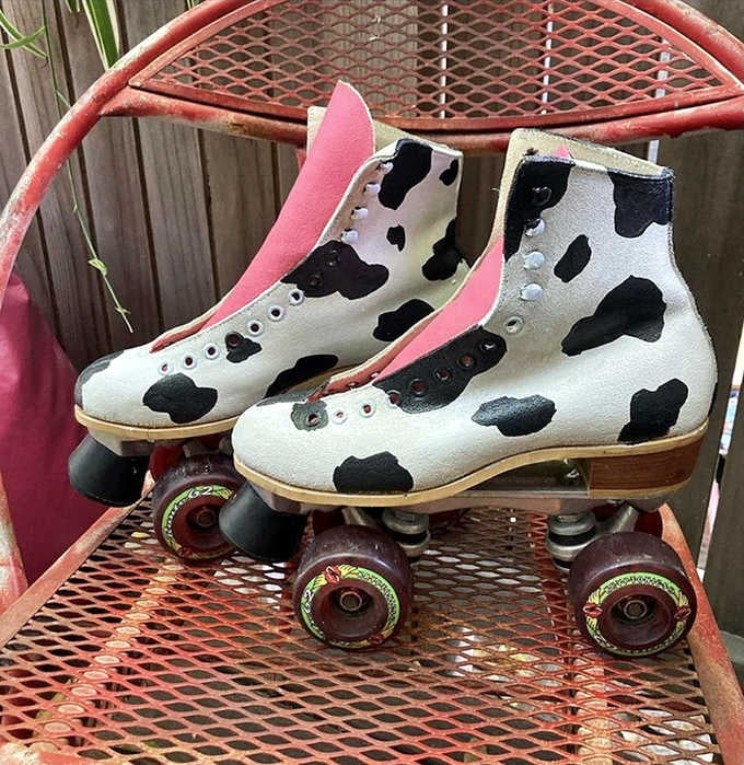 Cow-print roller skates that are either the coolest thing you've ever seen or proof someone's having too much fun.