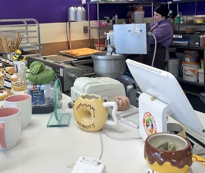 The purple walls and coffee station create a cheerful atmosphere where donut dreams are made and diets go to die.