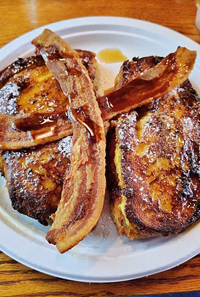 French toast with bacon that's been dusted with powdered sugar like it's wearing fancy evening attire.