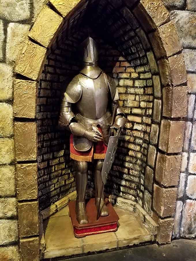 A suit of armor stands ready in an alcove, reminding you that medieval fashion was heavy, shiny, and terrible for summer.