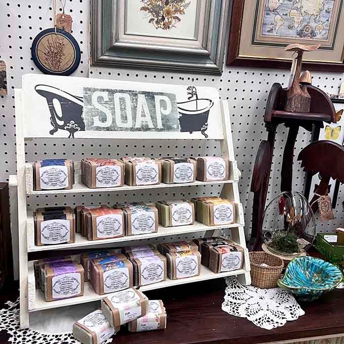 Handmade soaps displayed beneath vintage bathroom signage, blending old-school charm with modern artisan sensibility perfectly.
