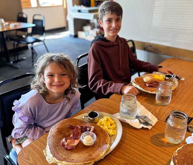 Young diners enjoying pancakes with all the fixings, proving great breakfast transcends generations and creates lasting family memories.