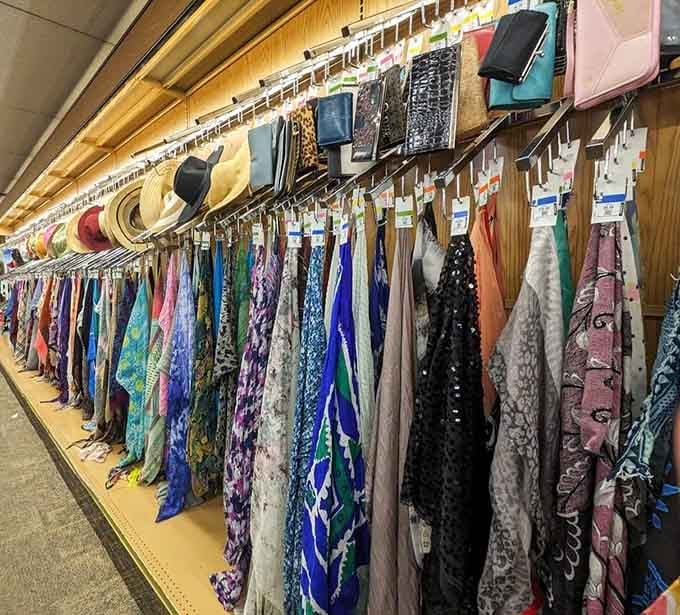 Scarves and accessories line the wall like a fabric art installation, each piece ready to complete an outfit perfectly.