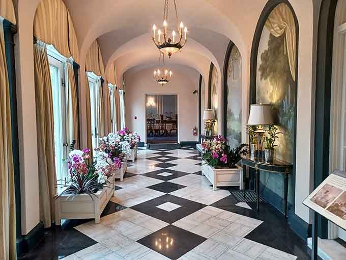 Arched ceilings and checkerboard floors create an elegant corridor that whispers of old-world sophistication and garden parties.