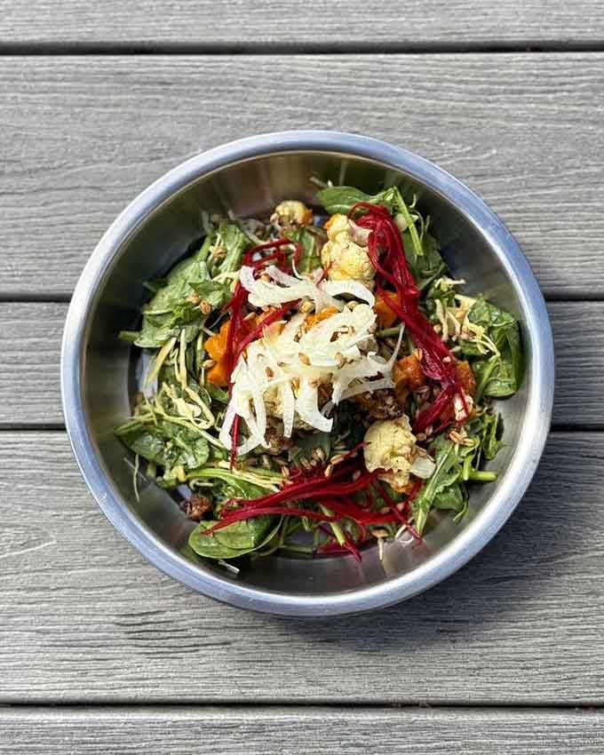 Fresh greens piled high with roasted vegetables prove salads can actually compete with their sandwich neighbors.