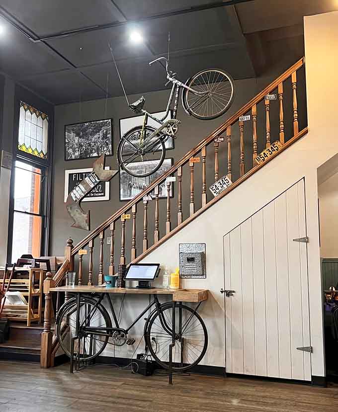That bicycle mounted above the staircase is either brilliant decor or someone's parking job gone spectacularly, wonderfully wrong in the best way.