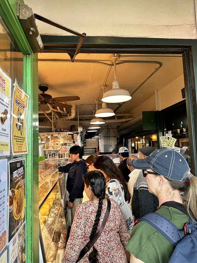 When strangers willingly stand this close together, you know something extraordinary is happening just beyond that green doorway ahead.