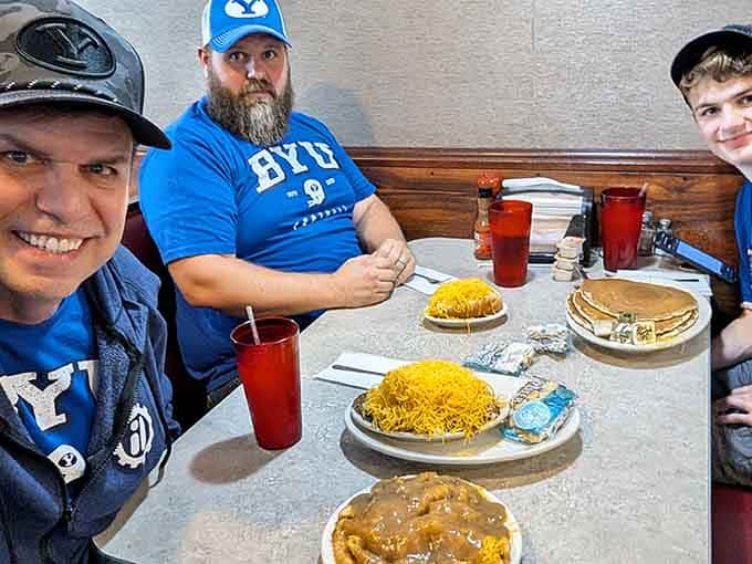 Happy diners enjoying their chili mountains, faces showing the universal expression of people who made excellent life choices today.