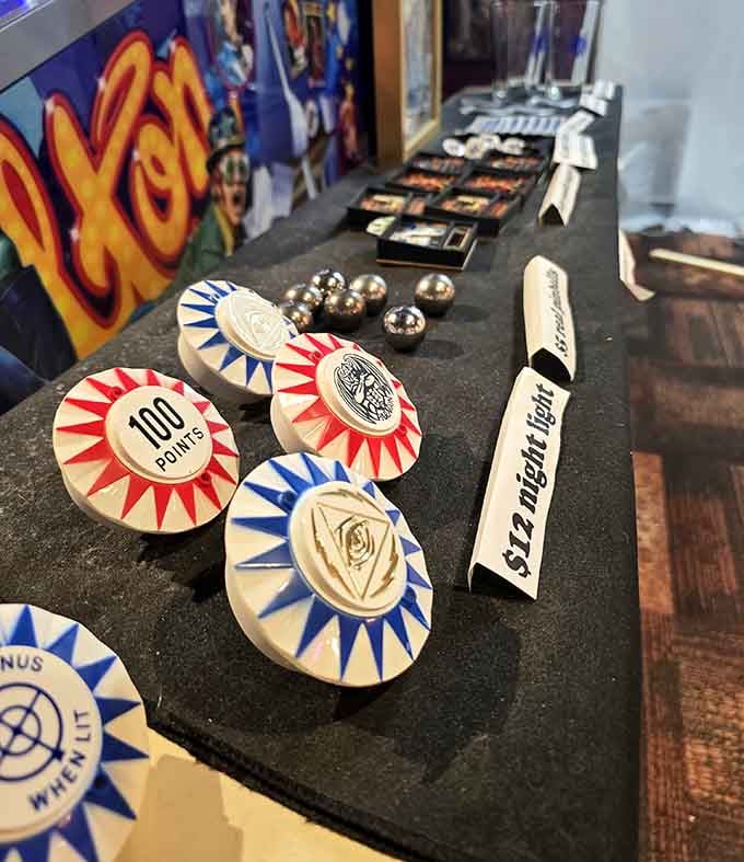 Vintage pinball tokens and accessories displayed like the precious artifacts of arcade history they truly are.
