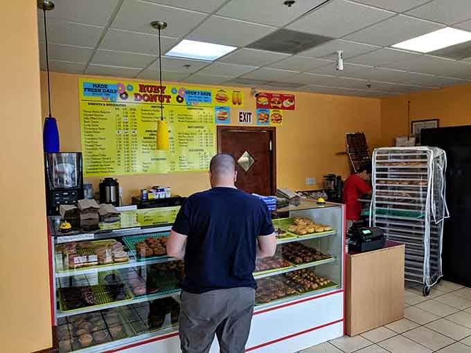 A customer contemplates the serious business of selecting the perfect donuts from Ruby's impressive lineup.