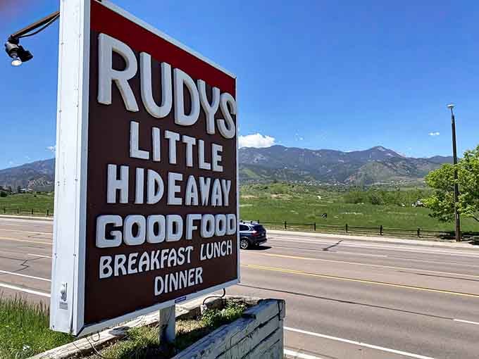 The roadside sign promises good food for breakfast, lunch, and dinner with mountains as your backdrop.