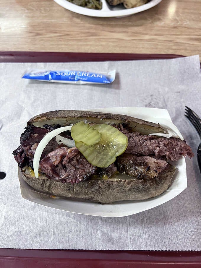 A loaded baked potato that's been topped with brisket, proving that carbs and smoked meat are soulmates forever.