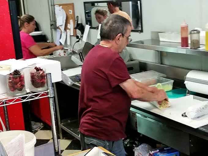 Behind the scenes, skilled hands craft sandwiches with the precision of artists working their chosen medium.