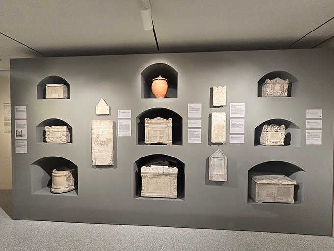 Ancient Roman funerary artifacts nestle in wall niches, each one a small window into lives lived millennia ago.
