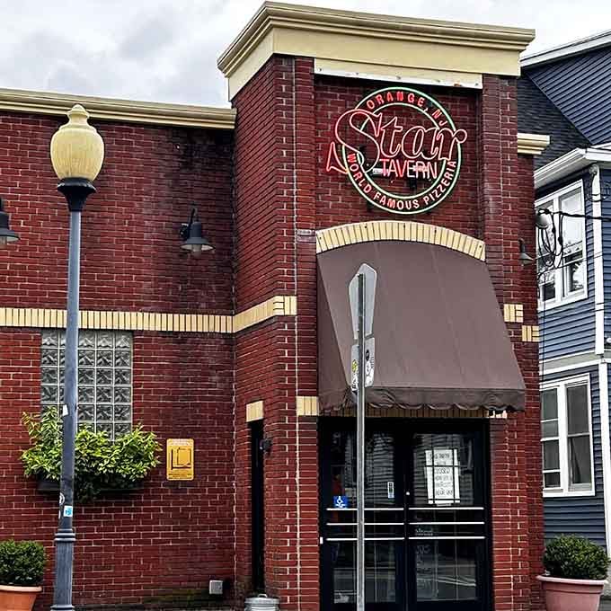 The neon sign glows like a beacon calling pizza lovers home from miles away, day or night always.