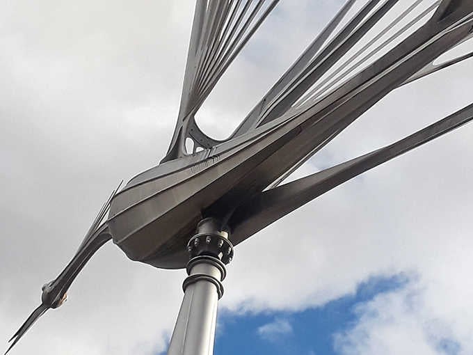 Up close, you can appreciate the precision engineering that allows these massive sculptures to spin on a single bearing point.