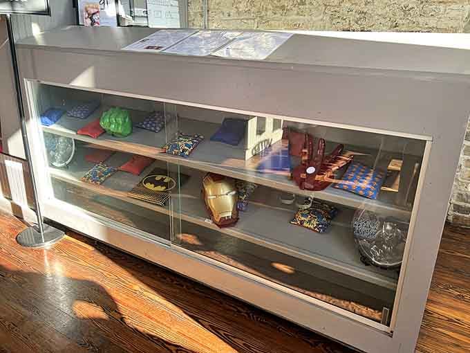 Superhero memorabilia displayed like museum pieces, because your breakfast spot should also celebrate your childhood heroes properly.