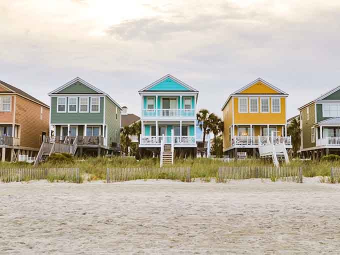 Colorful beach houses lined up like a rainbow decided to retire by the ocean and live happily ever after.