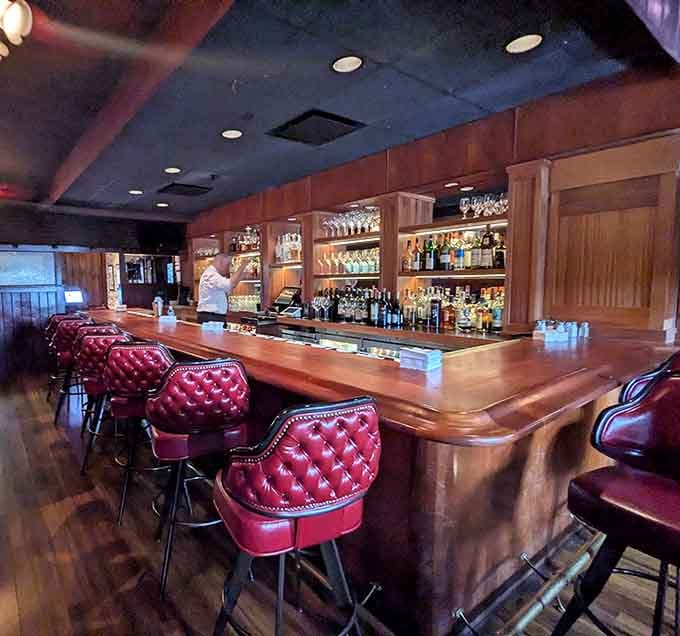 That polished wood bar with tufted burgundy stools practically begs you to settle in for a pre-dinner cocktail.