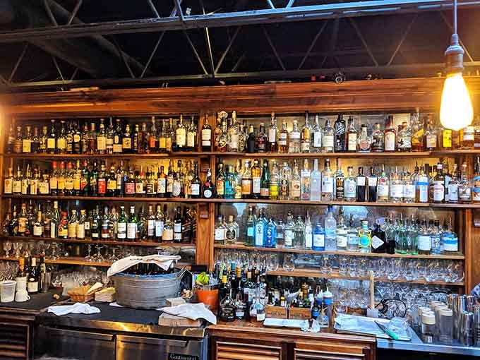 That back bar holds enough spirits to make any cocktail dream come true, arranged like liquid treasure on wooden shelves.